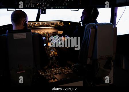 Team of airliner and captain using power switch on cabin dashboard to ...