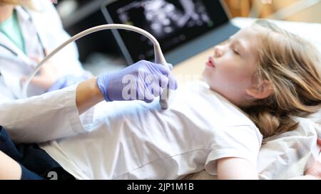 Doctor making diagnostic examination of internal organs in children ...