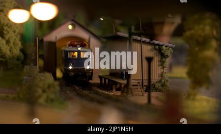 Toy diesel railway engine at depot station. Scale model railway layout ...