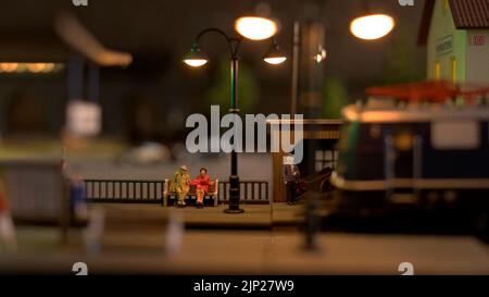 Toy diesel locomotive leaving the station. Miniature passenger train ...
