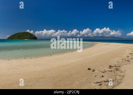 A mesmerizing view of the sandy Bon Bon Beach and a cliff with dense ...