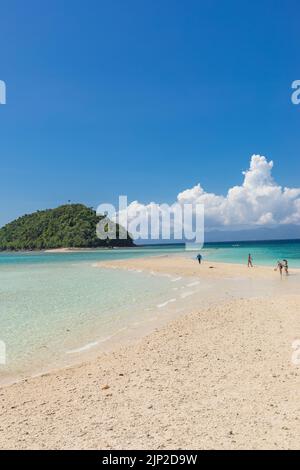 A mesmerizing view of the sandy Bon Bon Beach and a cliff with dense ...