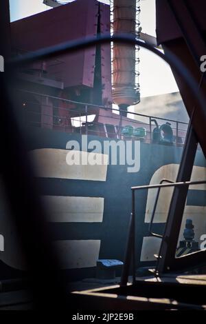 Loading grain into holds of sea cargo vessel in seaport from silos of ...