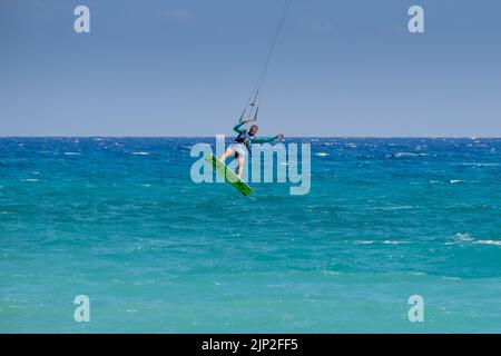 Man kitesurfing and jumping in the Beach of Agiokampos, Greece Stock ...
