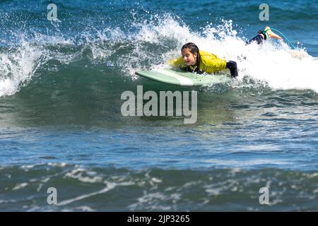 Photo with copy space of a smiley teen surfing on the sea Stock Photo ...