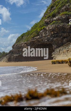 A vertical shot of a sandy beach being washed by the sea waves Stock ...