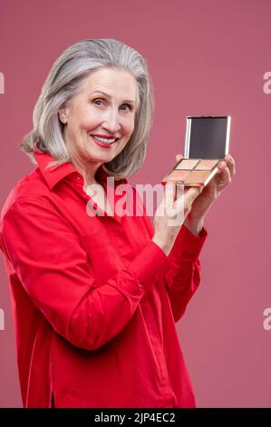 Woman holding powder box in hands and looking excited Stock Photo - Alamy