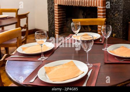 A round dinner table with arranged plates, napkins, and glasses Stock ...
