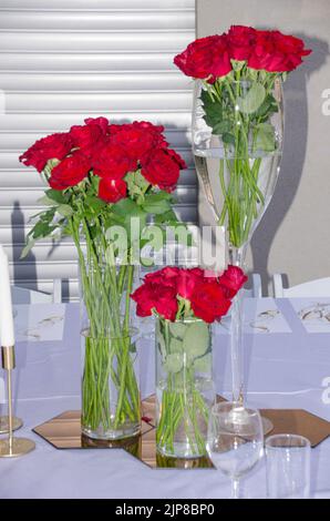 Bouquet of red roses decorates a table at a festive celebration and ...