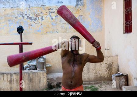 Indian wrestler exercising with Indian wooden clubs mugdar, Tulsi Ghat ...