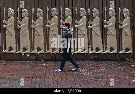 Mumbai, India. 16th Aug, 2022. A Parsi man holding an umbrella walks ...