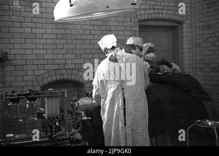 1953, historical, inside an operating theatre, two surgeons at work ...