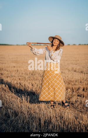 Young woman playing on woodwind wooden flute - ukrainian telenka or ...