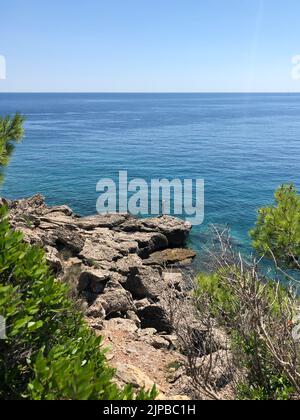 A fisherman standing on the beach with big waves at sunset Stock Photo ...