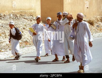 Schoolboys walking home in Rostaq, Sultanate of Oman. They wear the ...
