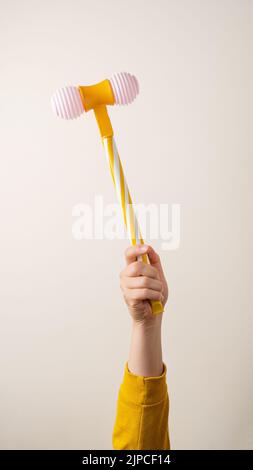 toy hammer in hand against light background Stock Photo - Alamy