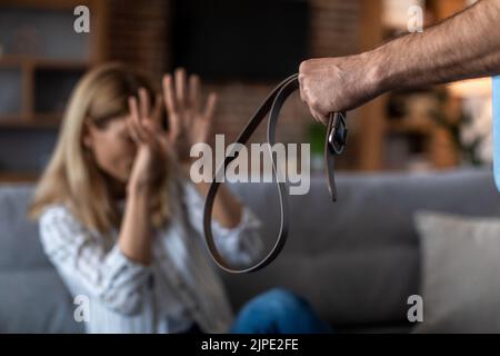 Angry husband beating his wife with belt at home. Domestic violence ...