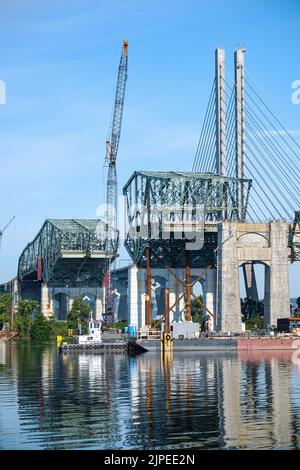 An old bridge is under demolition next to a new cable-stayed bridge ...