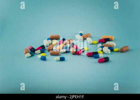 Simple pile of colorful pills. Medicines, pills stacked on blue ...