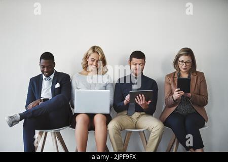 Make the waiting process productive. Studio shot of businesspeople ...