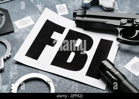 Paper sheet with abbreviation FBI and accessories of agent on wooden ...