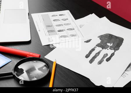Paper sheets with different prints and laptop at workplace of FBI agent ...