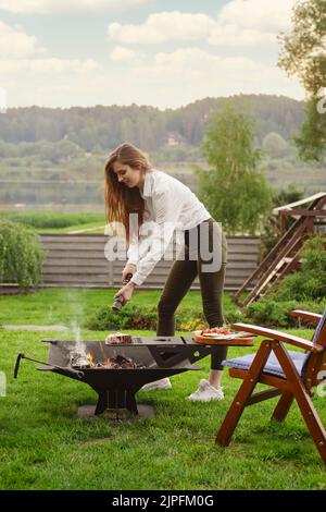 Young woman cooking beef in her kitchen Stock Photo - Alamy