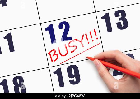 12th day of the month. Hand writing text WEDDING and drawing a red ...