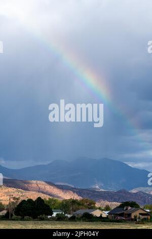 A rain storm over the La Sal Mountains with a rainbow, near Moab, Utah ...