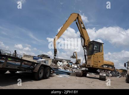 A large Caterpillar track material handler with an attached magnet ...