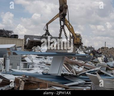 A large Caterpillar track material handler with an attached magnet ...