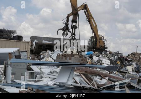 A large Caterpillar track material handler with an attached magnet ...