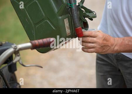 Male Refilling Plastic Glass with Fuel Stock Photo - Alamy