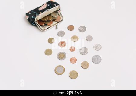 Open wallet with different coins isolated on white background top view ...