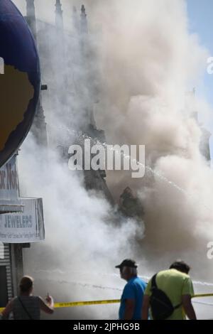 The crowd of people, firefighters, and policemen in the street during ...