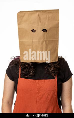 Woman wearing paper bag over her head and holding her hands to pray ...