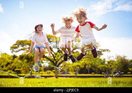 Cute little children jumping rope in park Stock Photo - Alamy