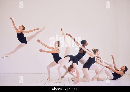 The group of modern ballet dancers dancing on gray studio background ...