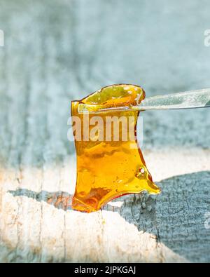 golden cannabis wax resin smear on dark background Stock Photo - Alamy
