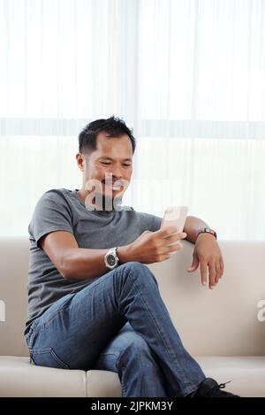 Asian man resting on sofa with fever and medicine at home Stock Photo ...