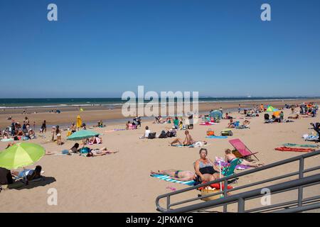 Sun tanning people at the beach of Benerville-sur-Mer, Normandy, France ...
