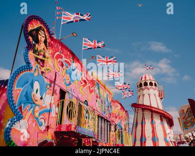 A colourful summer seaside funfair amusement park / pleasure beach with ...