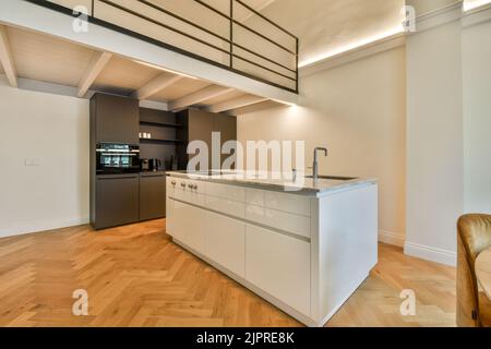 Wooden table and comfortable chairs placed near kitchen furniture in ...