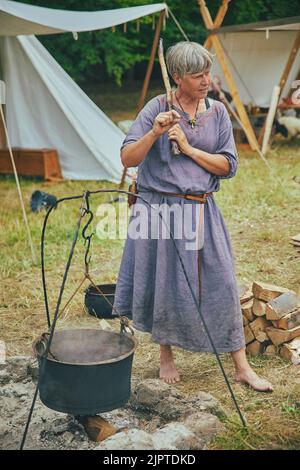 Woman in rustic linen dress holding natural easter eggs and spring ...