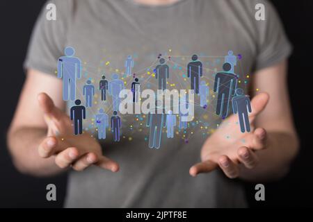 A man's hand pressing a group of illustrative human figures against a ...