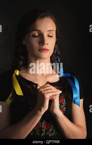 A girl with braided yellow and blue ribbons, the colors of the ...