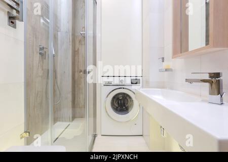 Modern style bathroom with washing machine and dryer combo. Vertical ...