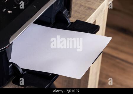 A portrait of a printer with an empty white page in its printed output ...