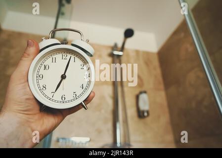 The clock shows 7 am. Time to take a shower Stock Photo - Alamy