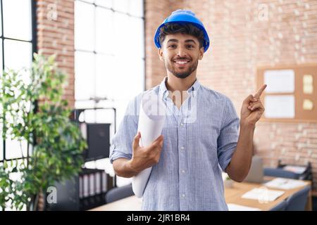 Arab man with beard wearing architect hardhat at construction office ...